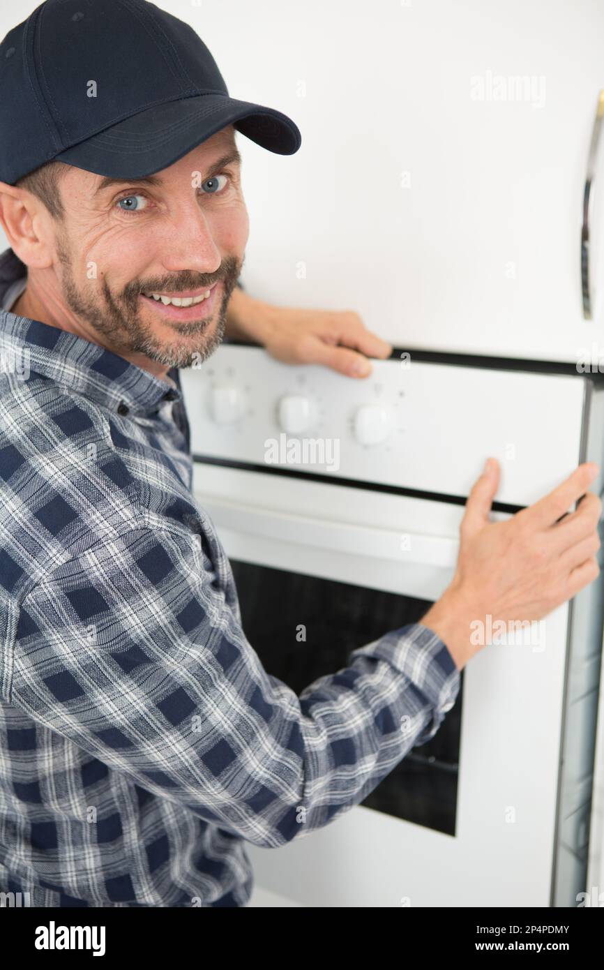 man fitting a new oven in kitchen Stock Photo - Alamy