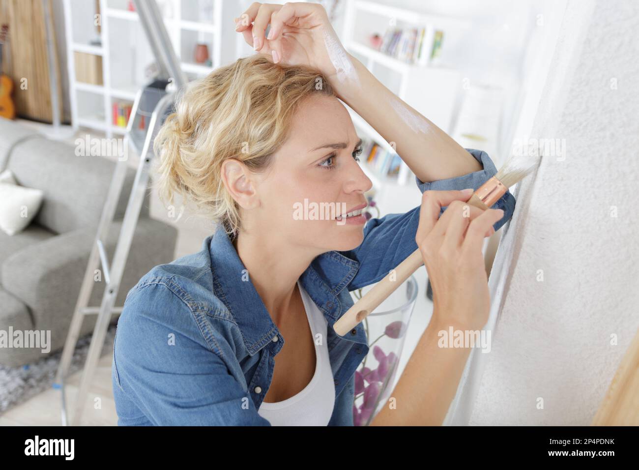tired woman painting wall paint smeared up her arm Stock Photo - Alamy