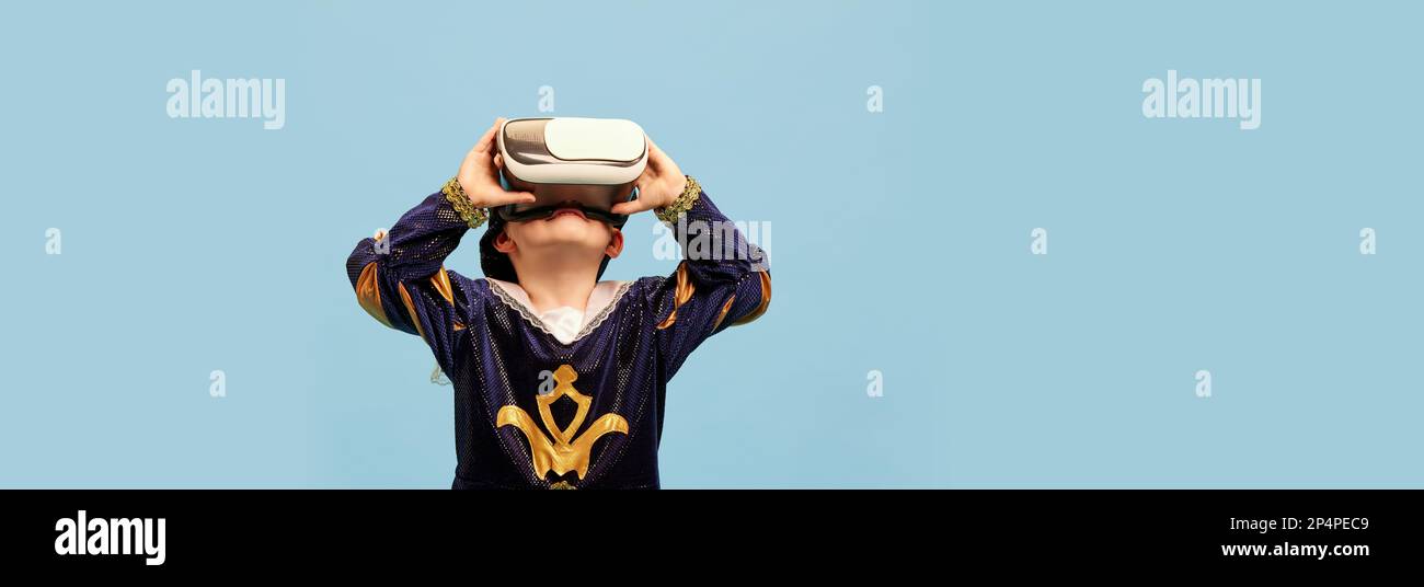 One little boy in costume of medieval pageboy, little prince wearing VR ...