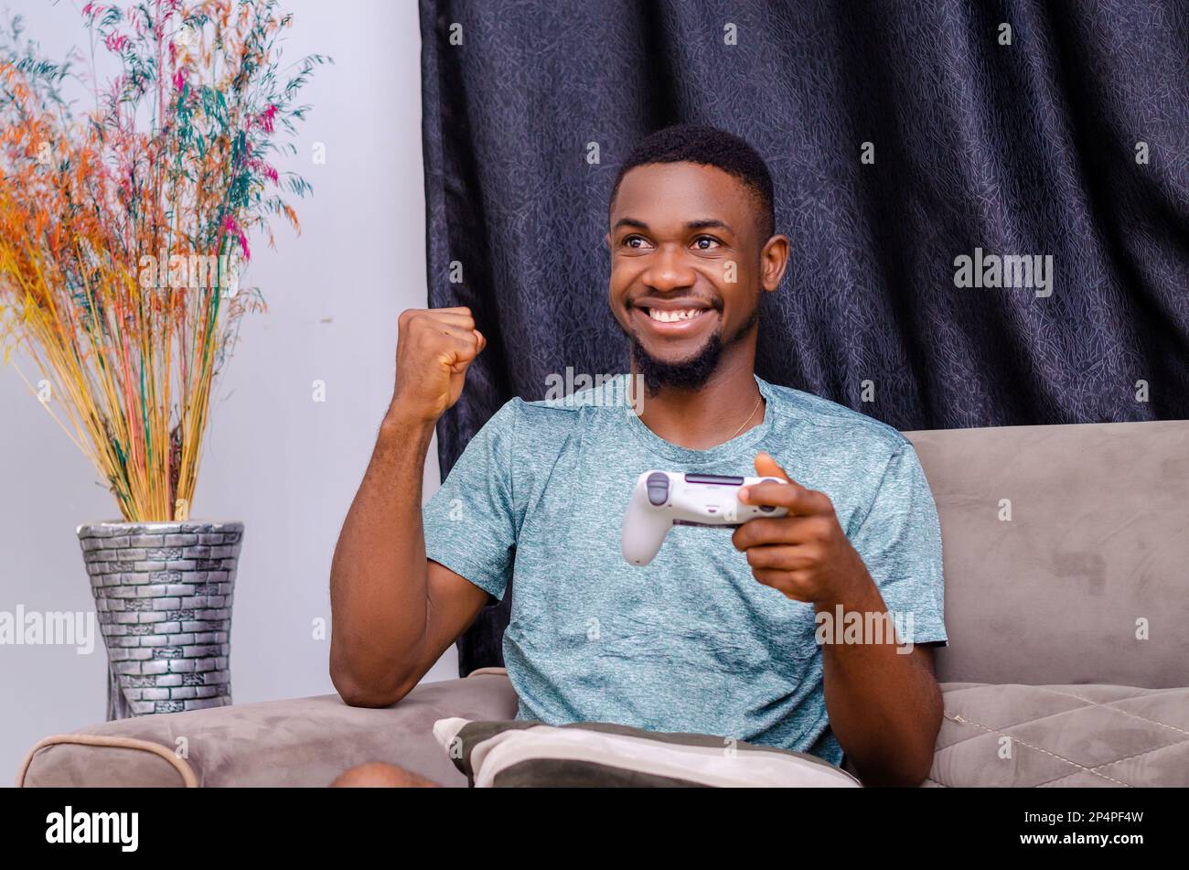 Young happy man laughing and playing video games on weekend Stock Photo ...