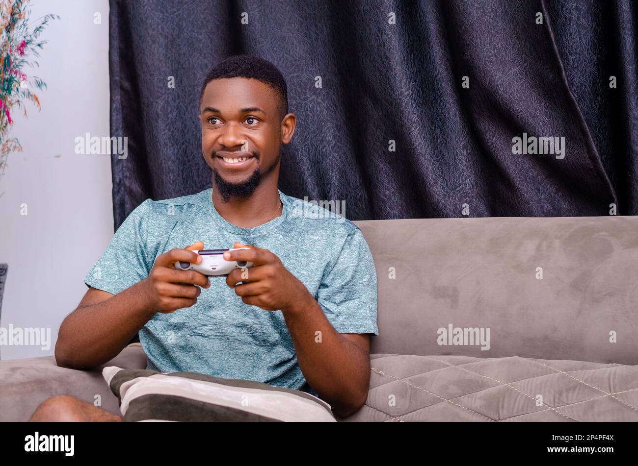 Young happy man laughing and playing video games on weekend Stock Photo ...