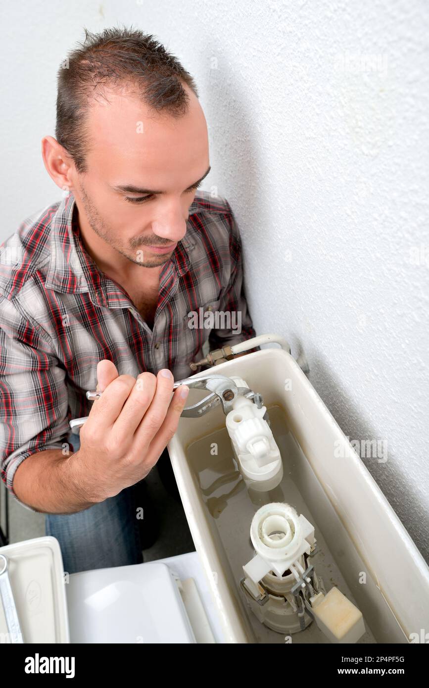 Man working on toilet cistern Stock Photo - Alamy