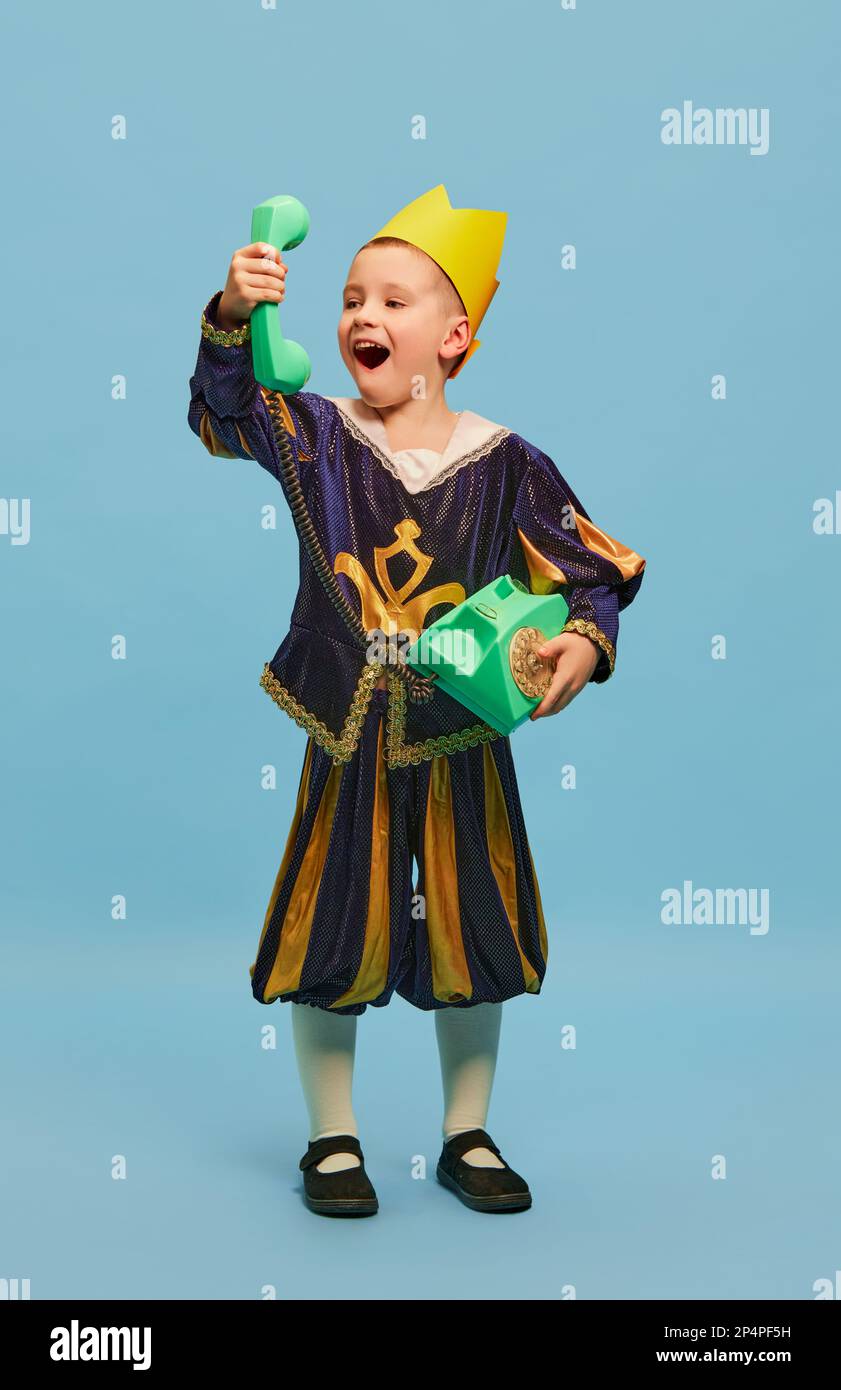 Joyful little cute boy in costume of medieval little prince in paper ...