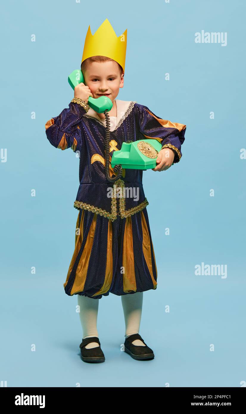 Joyful little cute boy in costume of medieval little prince in paper ...