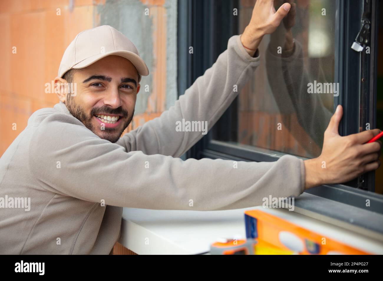 handsome young man installing bay window in a new house Stock Photo - Alamy