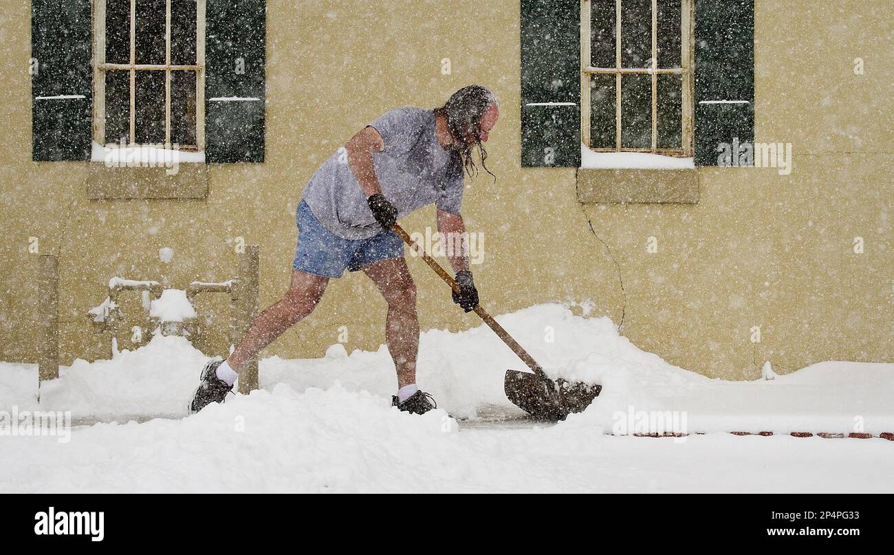 Troy Welty shovels snow in front of Mathew's Gallery where he works ...