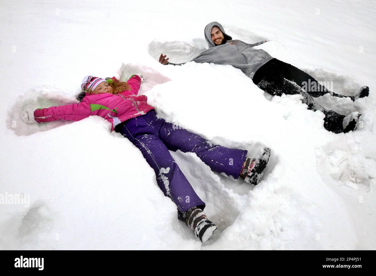 Brenah Wilcox, left, and her father, Jeremy, make snow angels together ...