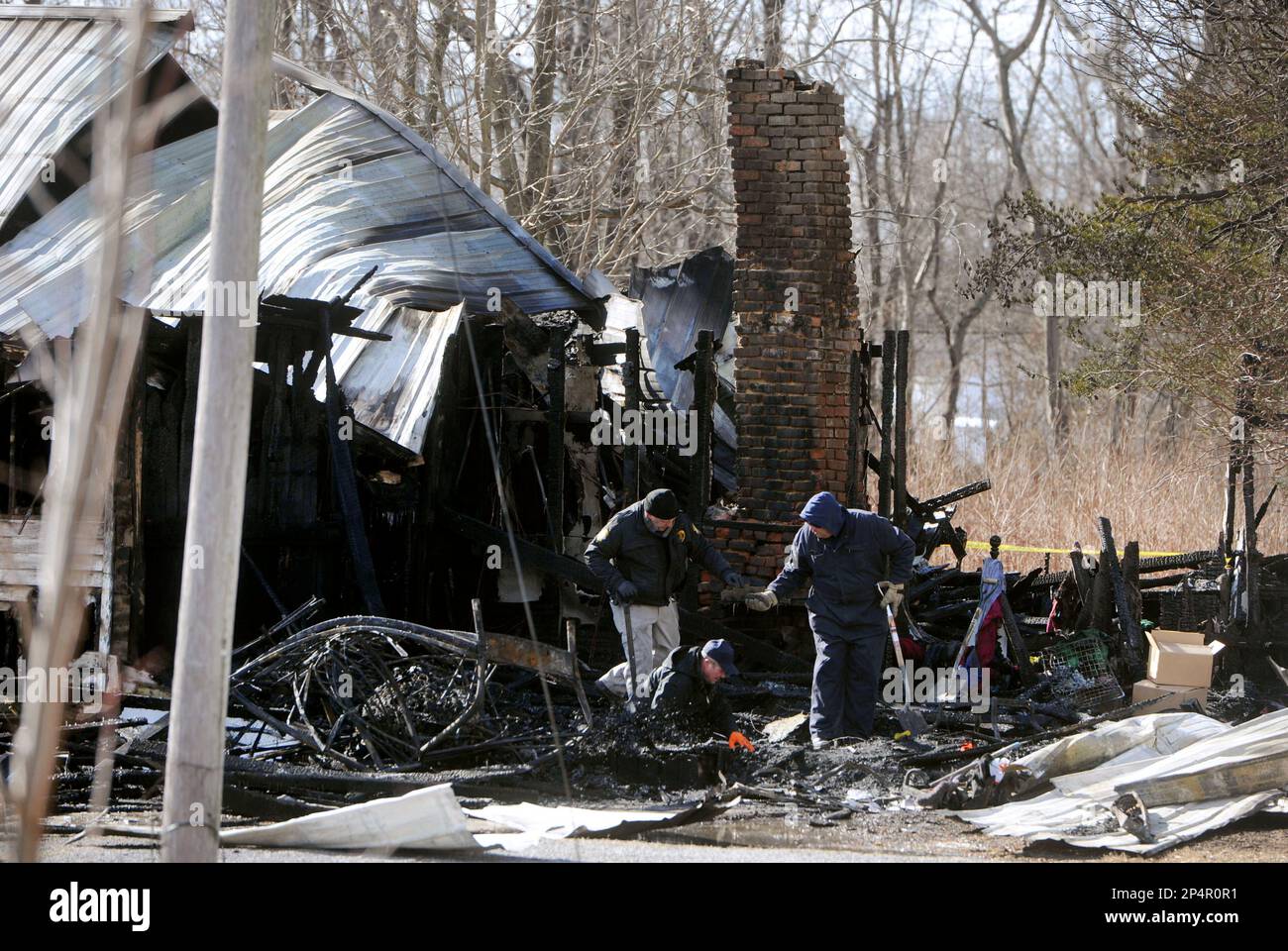 Alan Gregory, with the Kentucky Fire Marshal's office, at bottom, digs ...