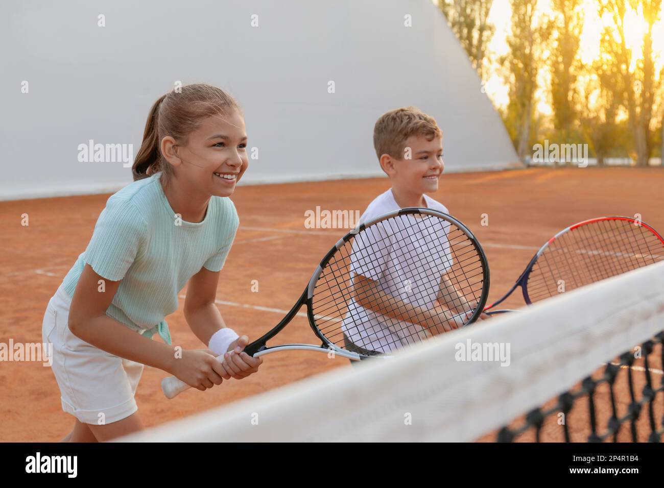 Happy children playing tennis on court outdoors Stock Photo - Alamy