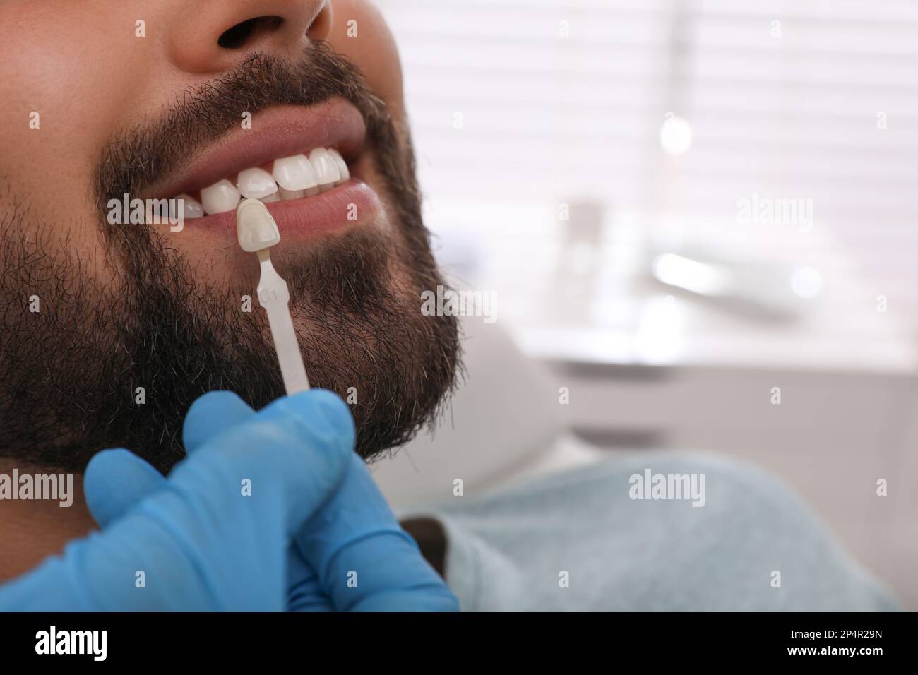 Dentist checking young man's teeth color in clinic, closeup Stock Photo ...