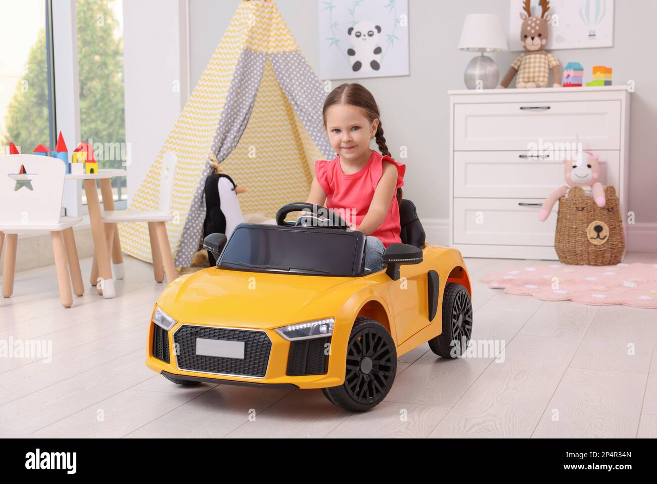 Adorable child driving toy car in room at home Stock Photo - Alamy
