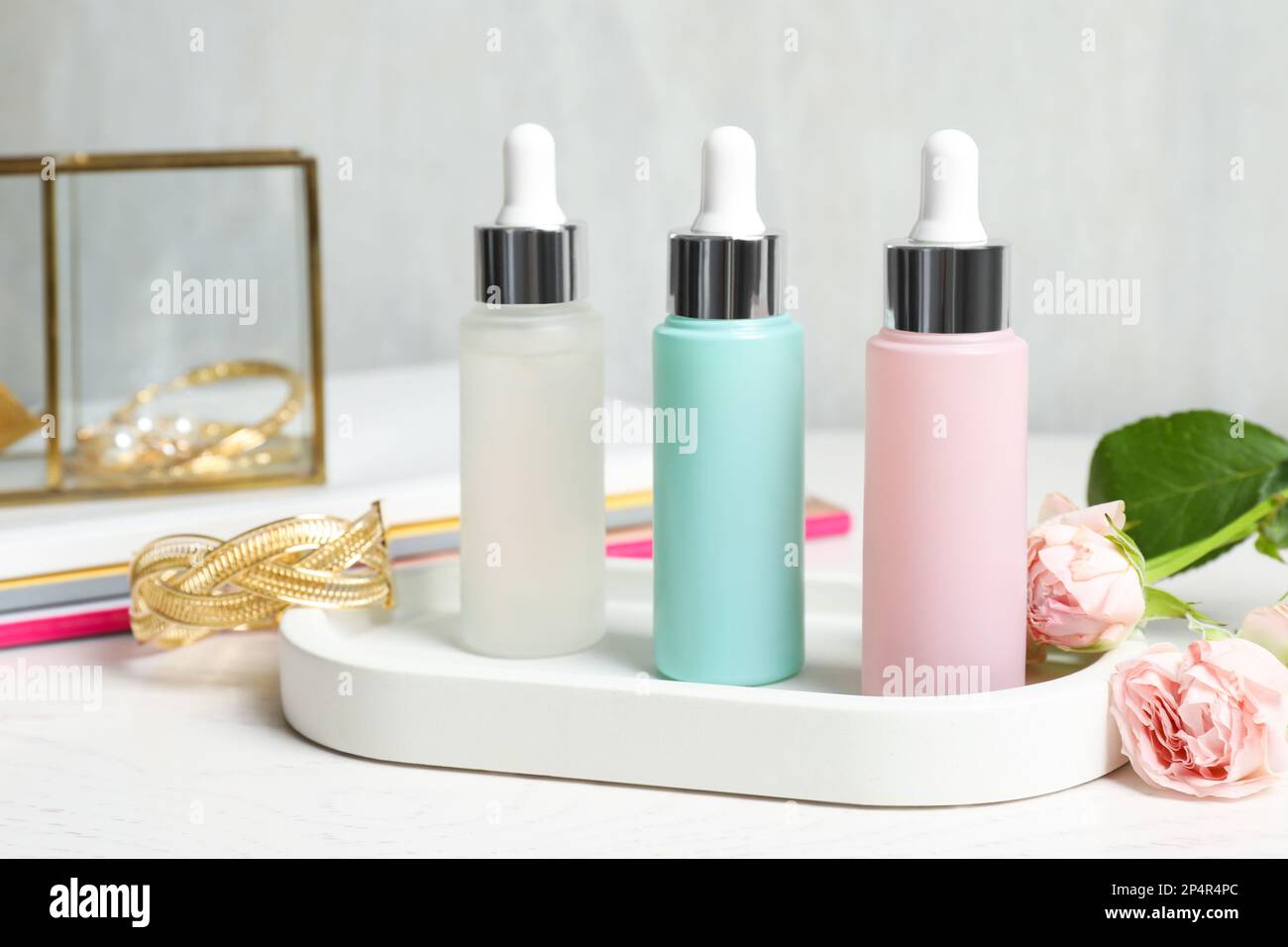 Different cosmetic products and ring on white table Stock Photo - Alamy