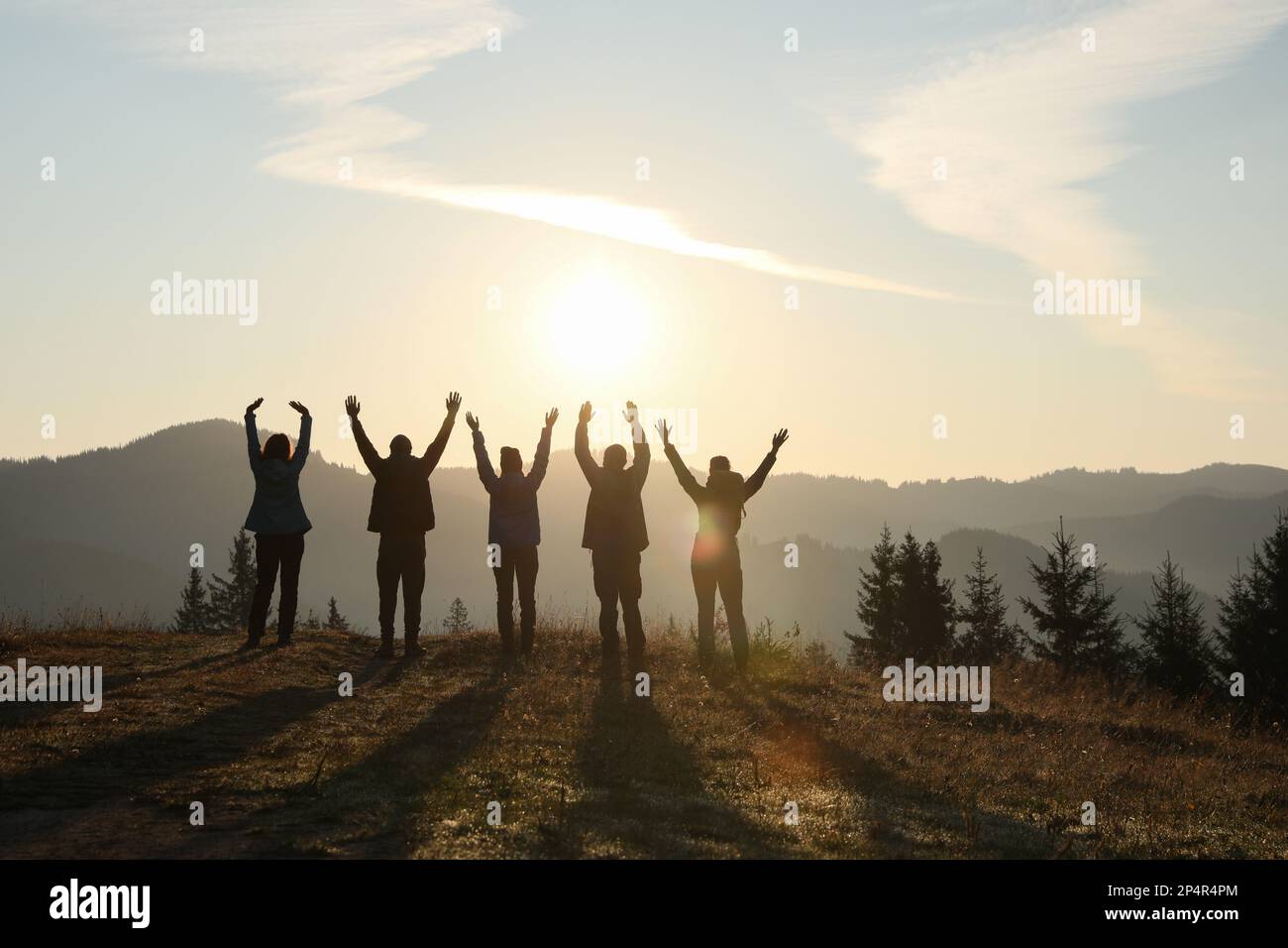Group of people enjoying sunrise in mountains, back view Stock Photo ...