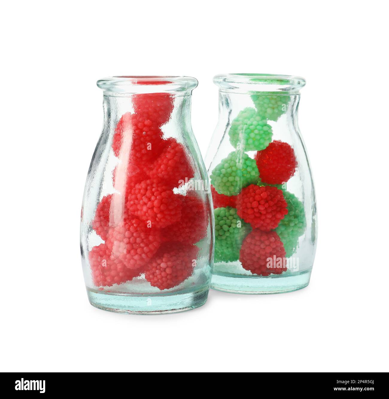 Delicious gummy raspberry candies in glass bottles on white background ...