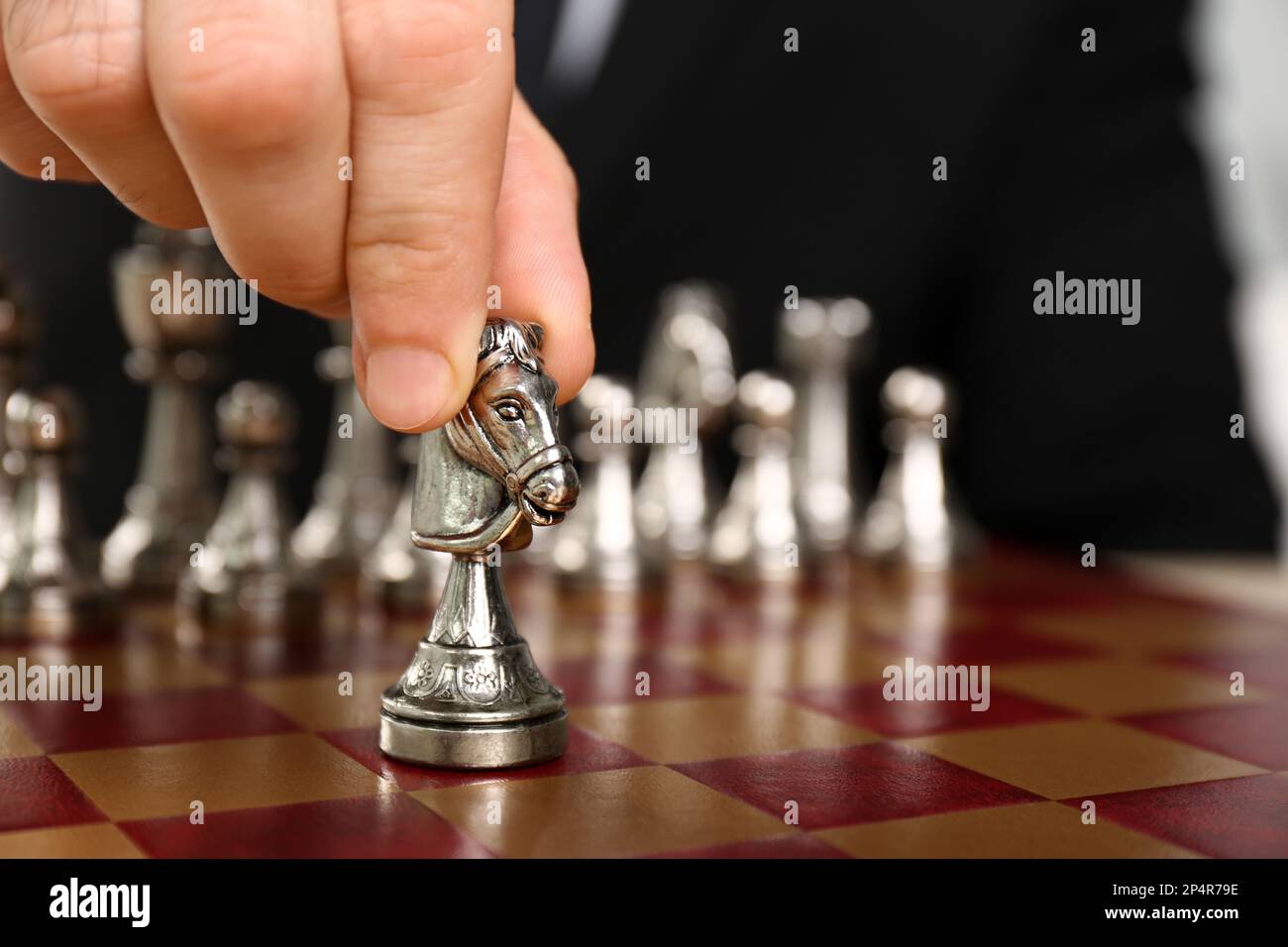 Man moving chess piece on board, closeup Stock Photo - Alamy