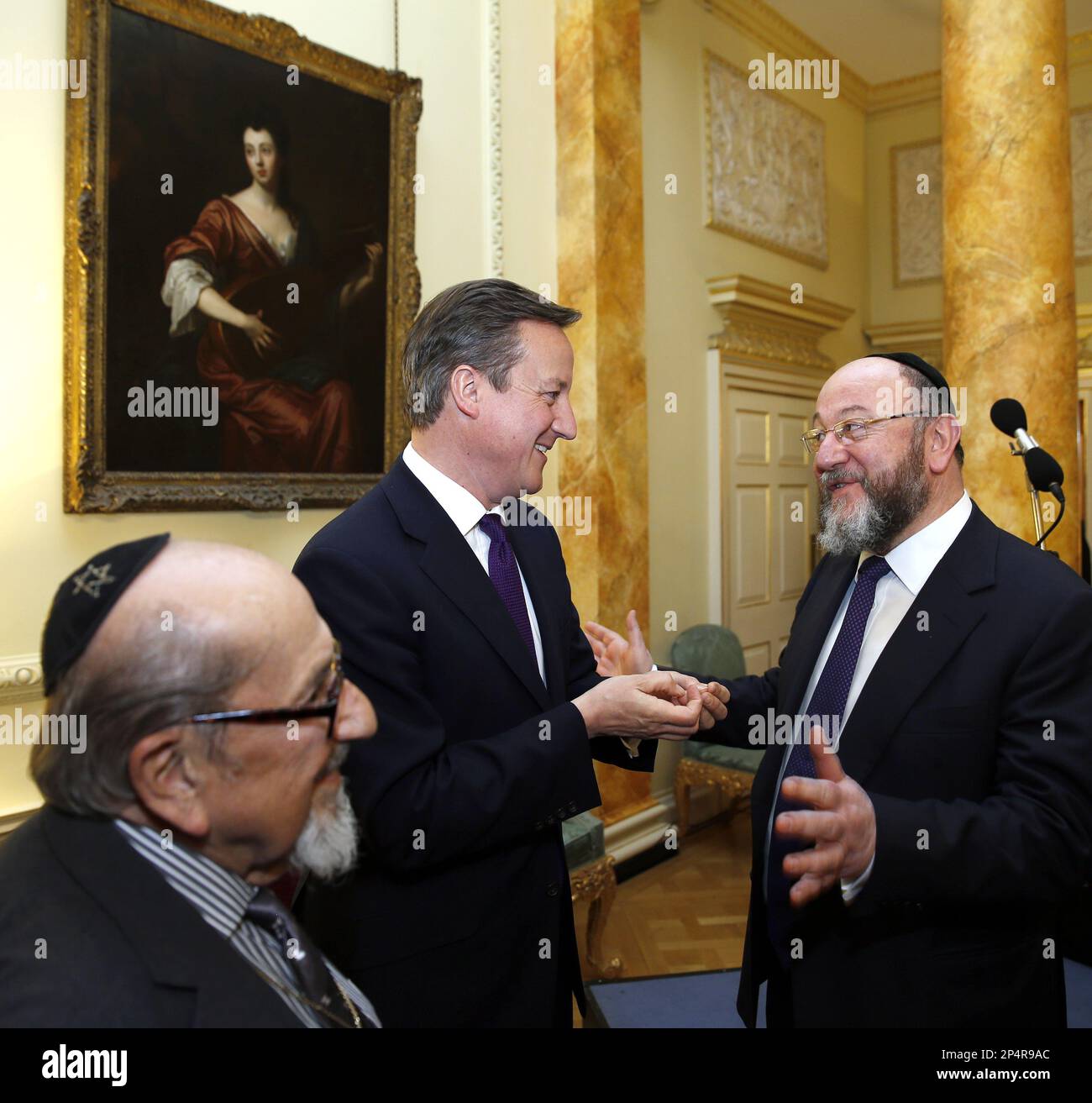 Britain's Prime Minister David Cameron, centre, talks with Chief Rabbi ...