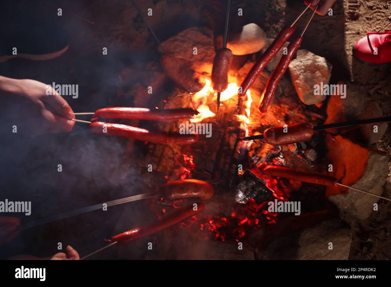 Woman roasting sausages campfire hi-res stock photography and images ...