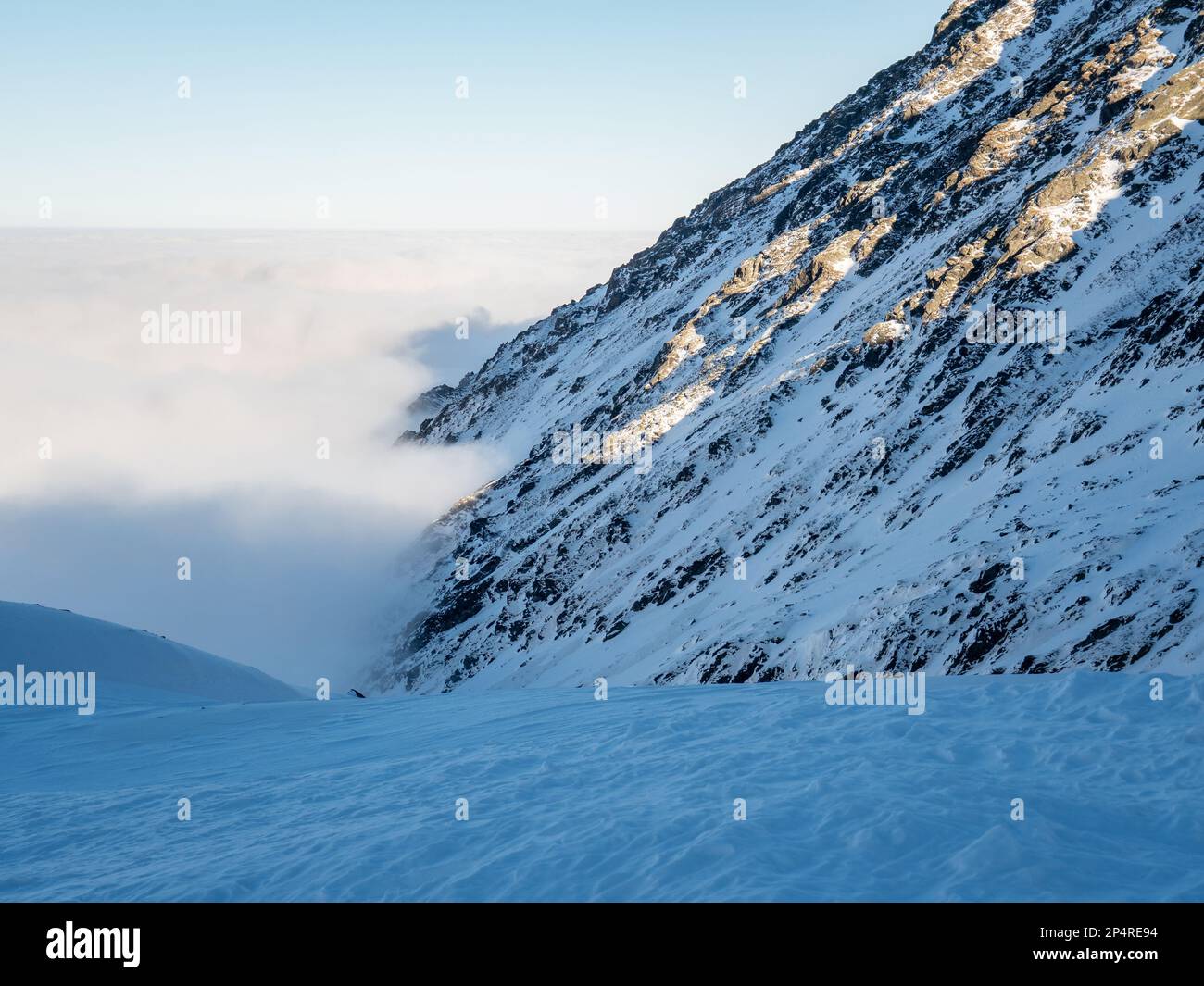 Snowy mountain view above the clouds in winter wonderland scene Stock ...