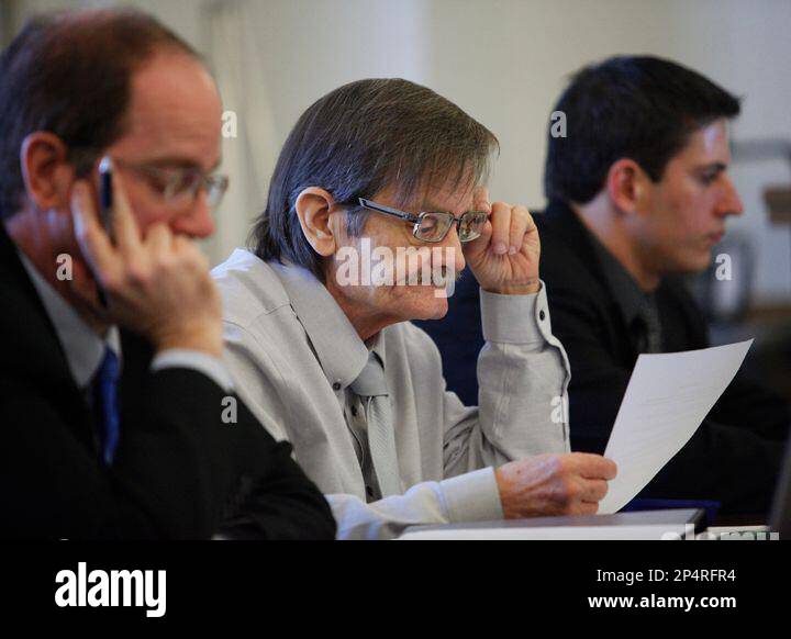 Robert Eugene Pilcher, center, reads over the instructions being ...