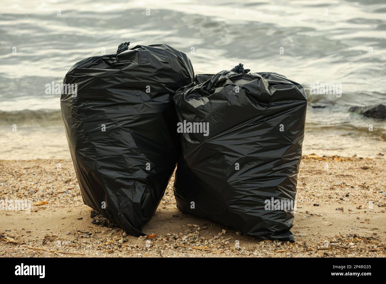 Trash bags full of garbage on beach Stock Photo - Alamy
