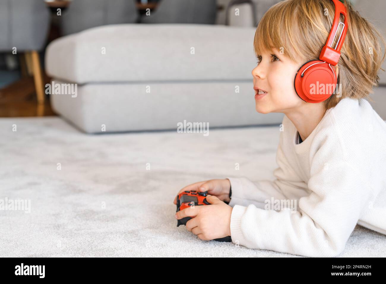 Little boy playing video game console using joystick or controller ...