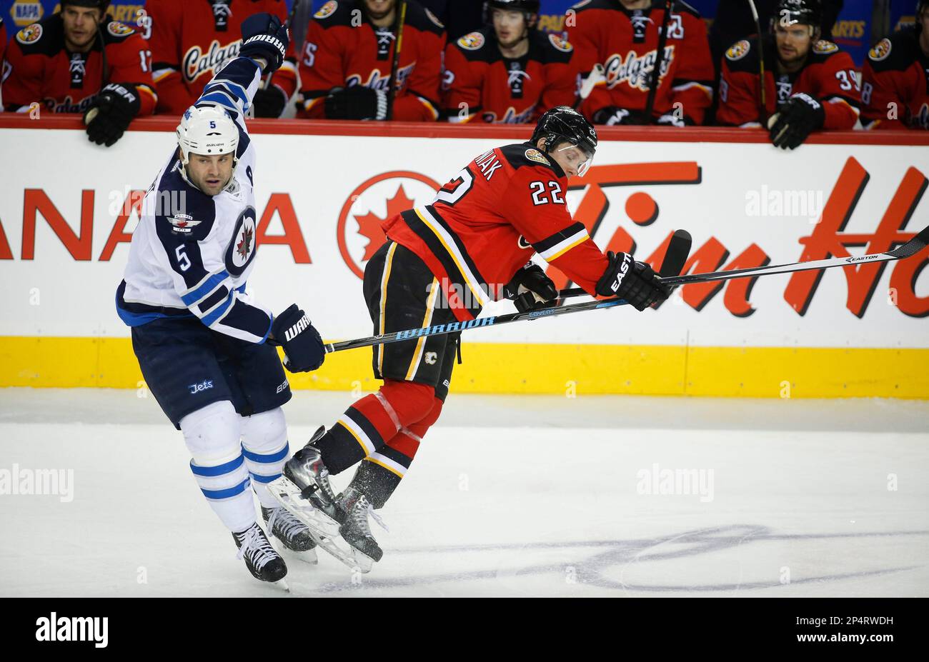 Winnipeg Jets' Mark Stuart, left, knocks Calgary Flames' Lee Stempniak ...