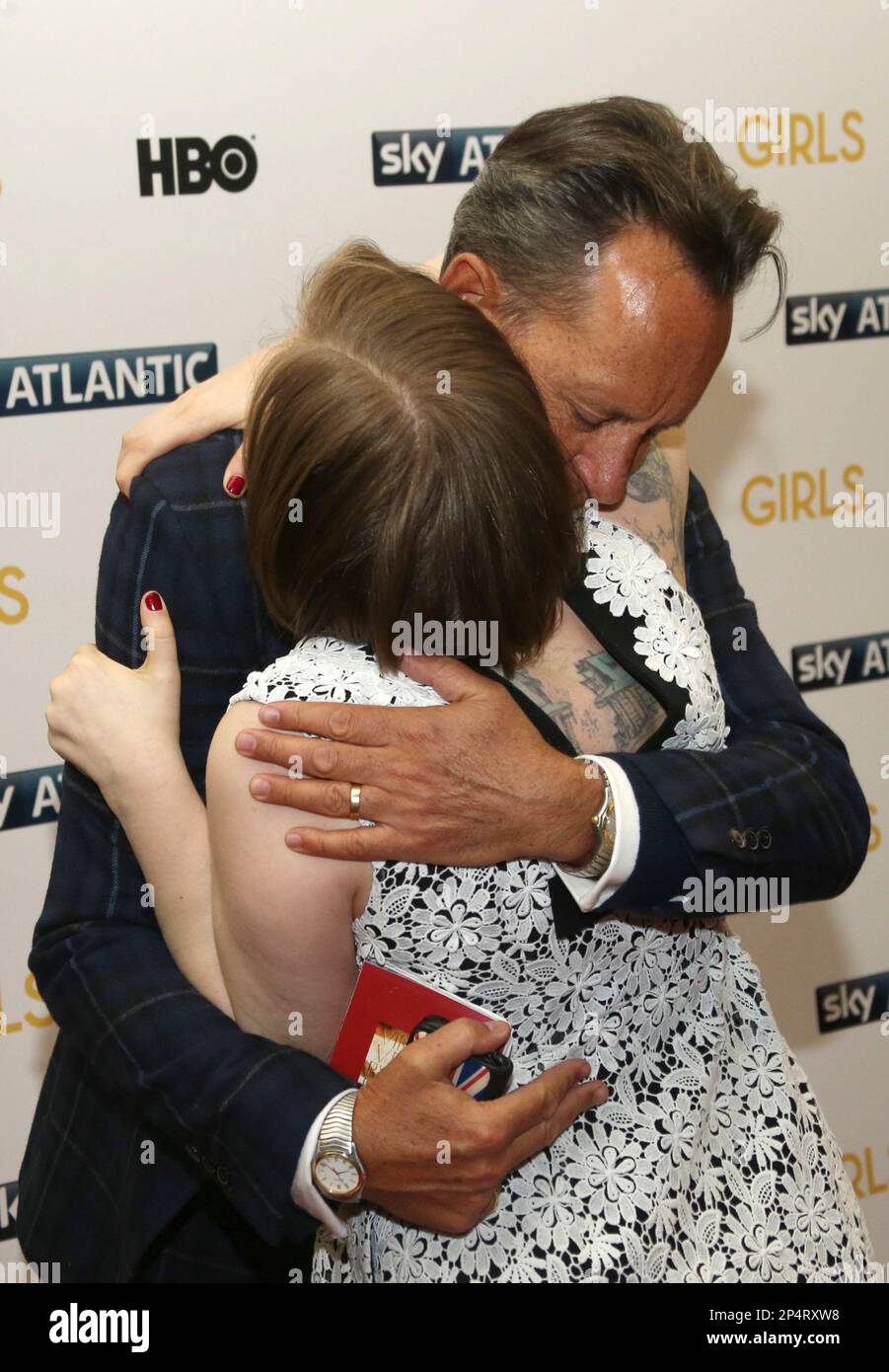 Actress Lena Dunham is hugged by British actor Richard E. Grant as she ...