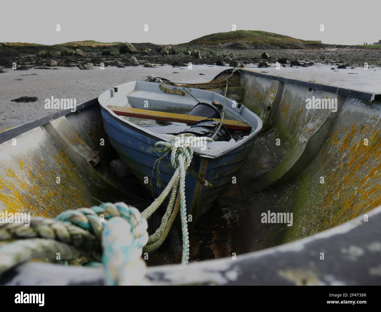 A wooden boat in a shallow pool of water at the edge of a coast Stock ...
