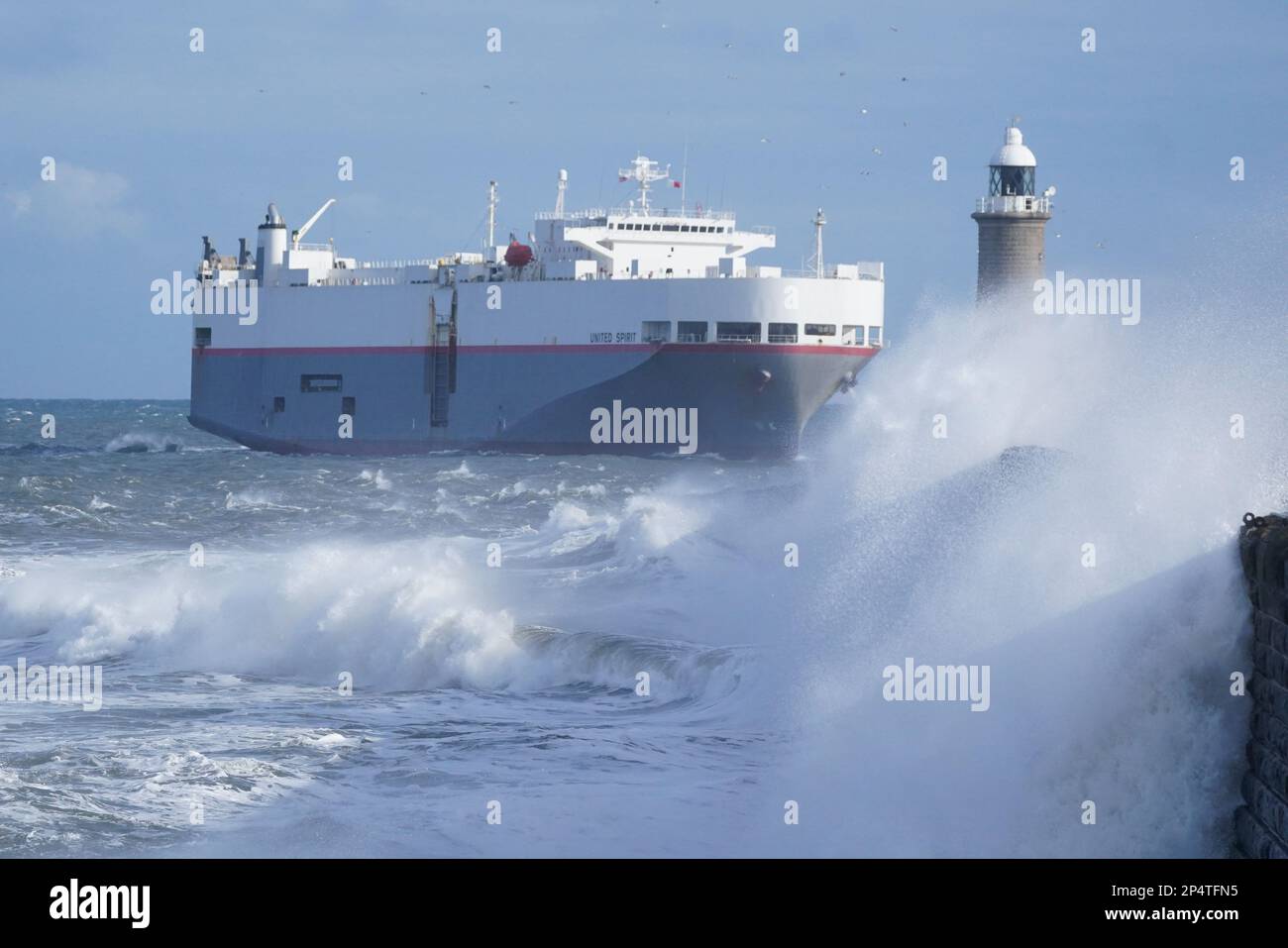 Waves crash over the Tynemouth pier lighthouse as a boat approaches the ...