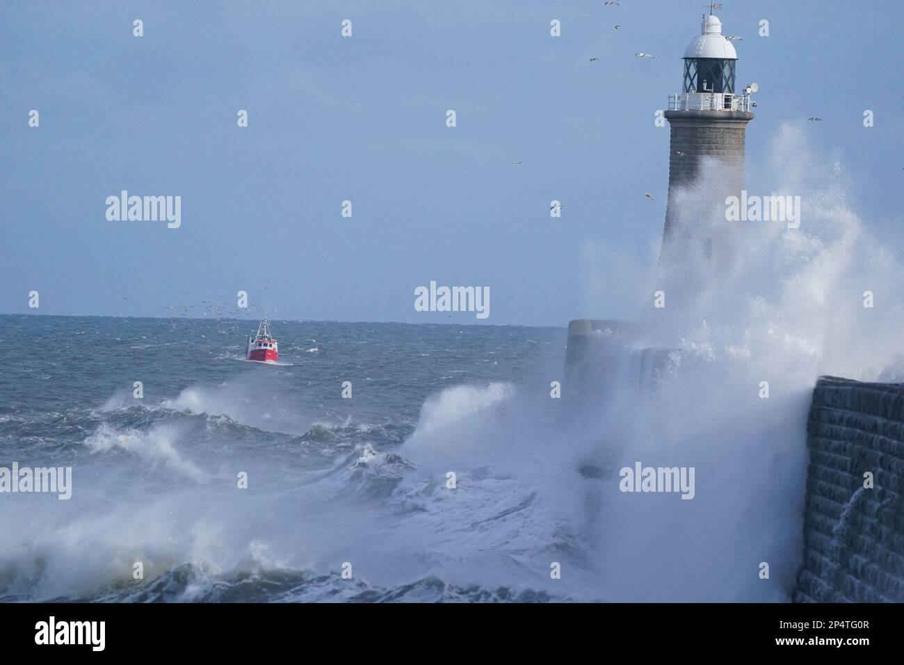 Waves crash over the Tynemouth pier lighthouse at the mouth of the ...