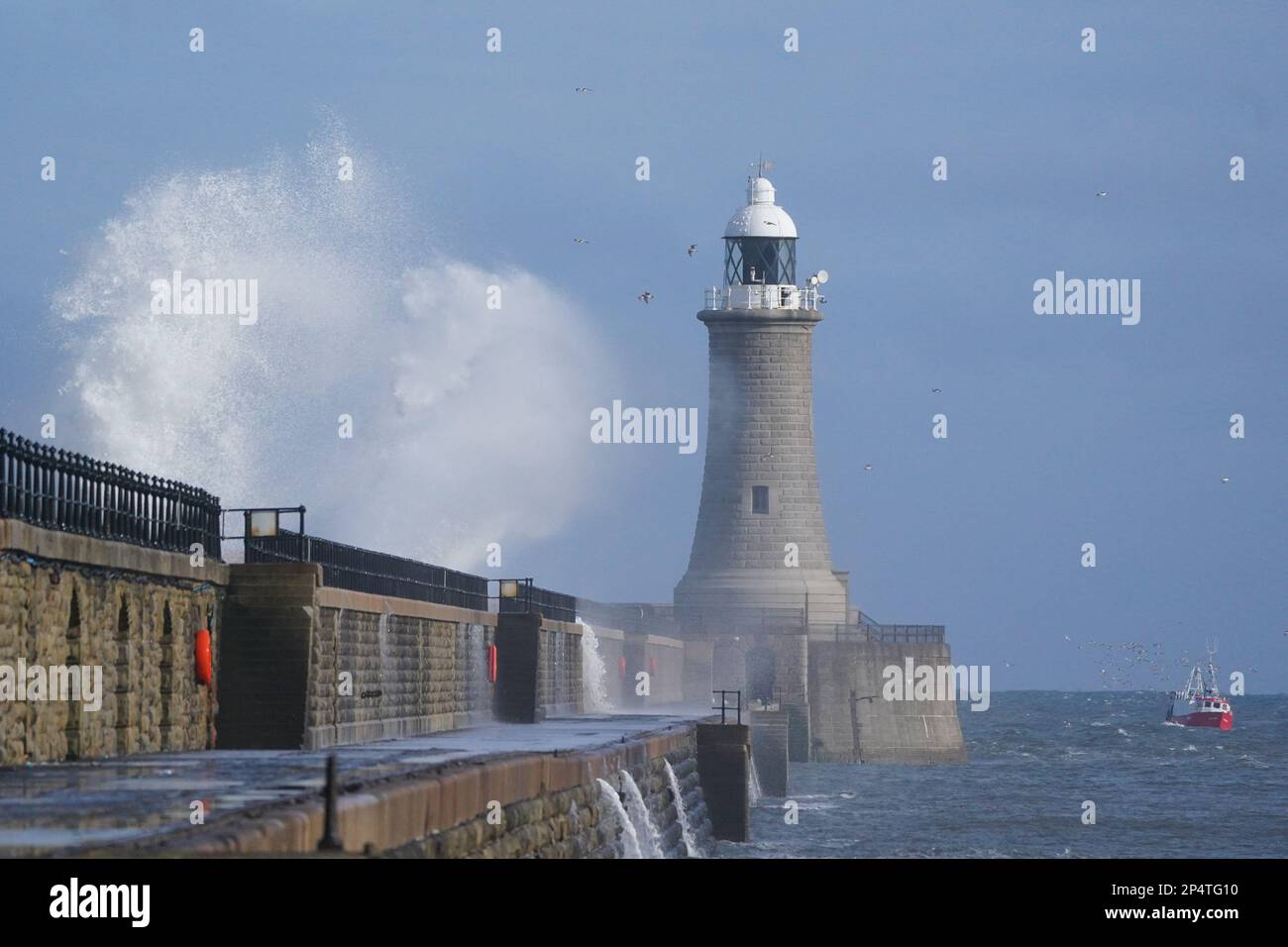 Waves crash over the Tynemouth pier lighthouse at the mouth of the ...