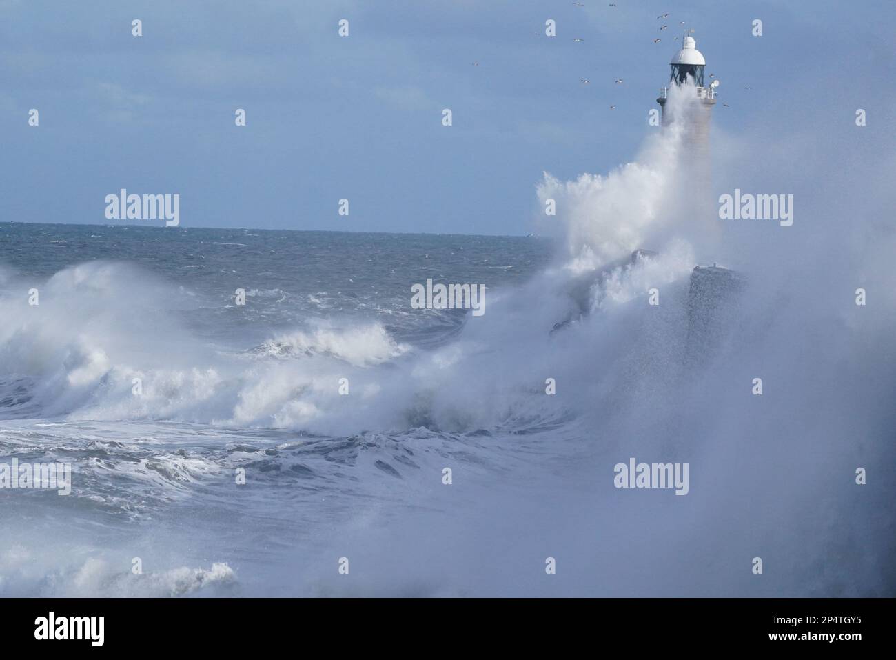 Waves crash over the Tynemouth pier lighthouse at the mouth of the ...