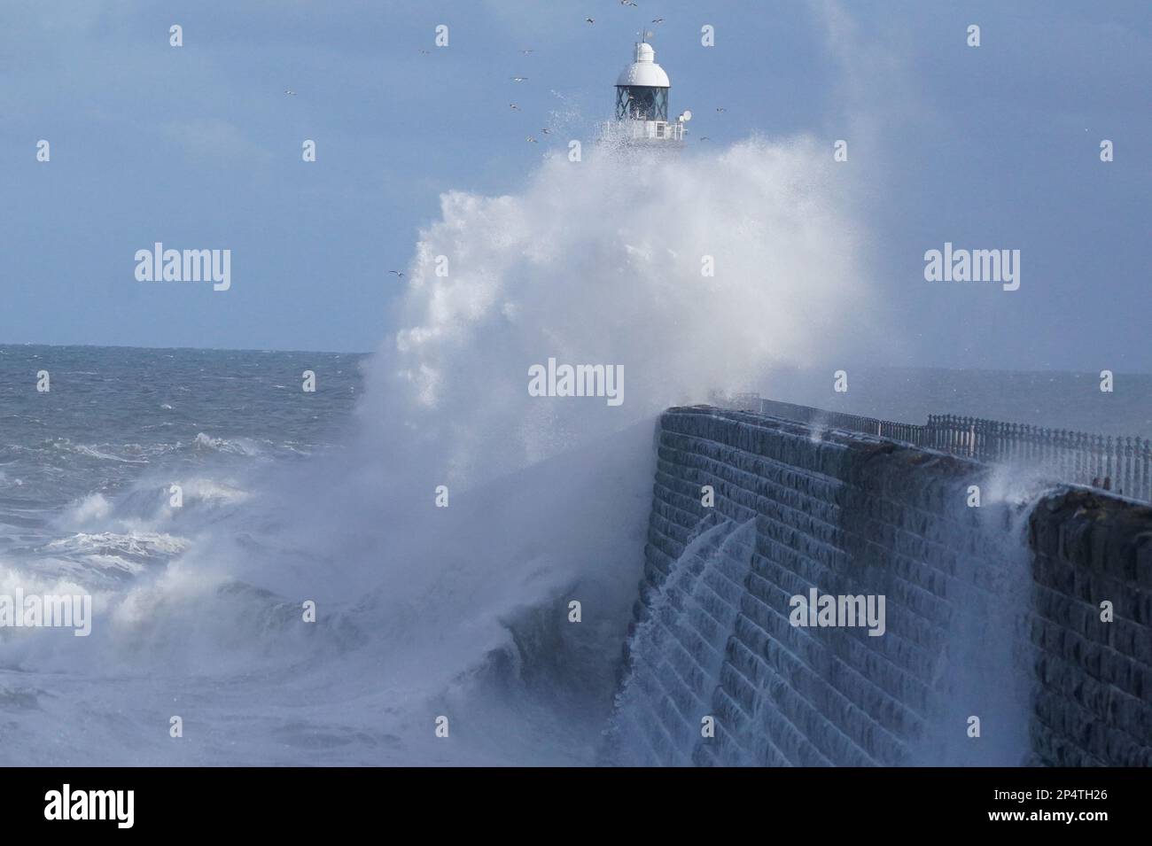Waves crash over the Tynemouth pier lighthouse at the mouth of the ...
