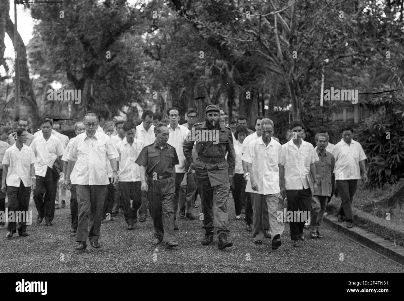 Cuban President Fidel Castro, center, walks with a cigar in his mouth ...