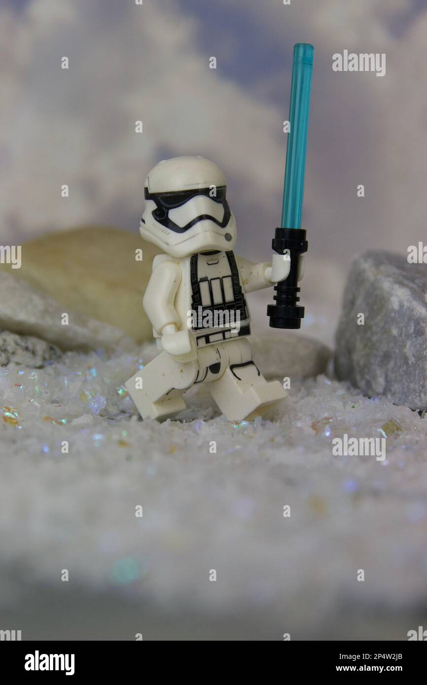 A whimsical toy figure is featured striding through a sandy desert ...
