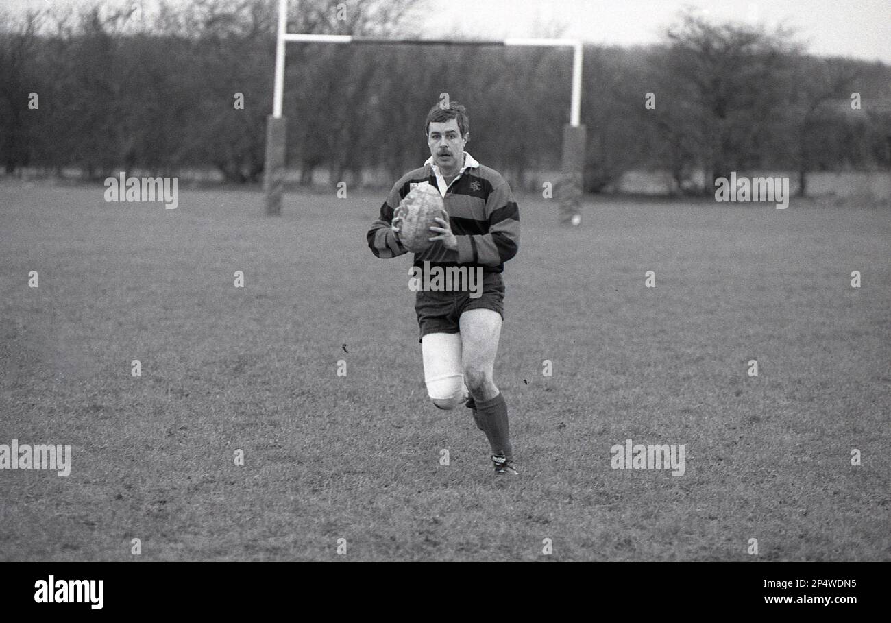 1980s, rugby union, outside on a rugby pitch, a wingback running with ...