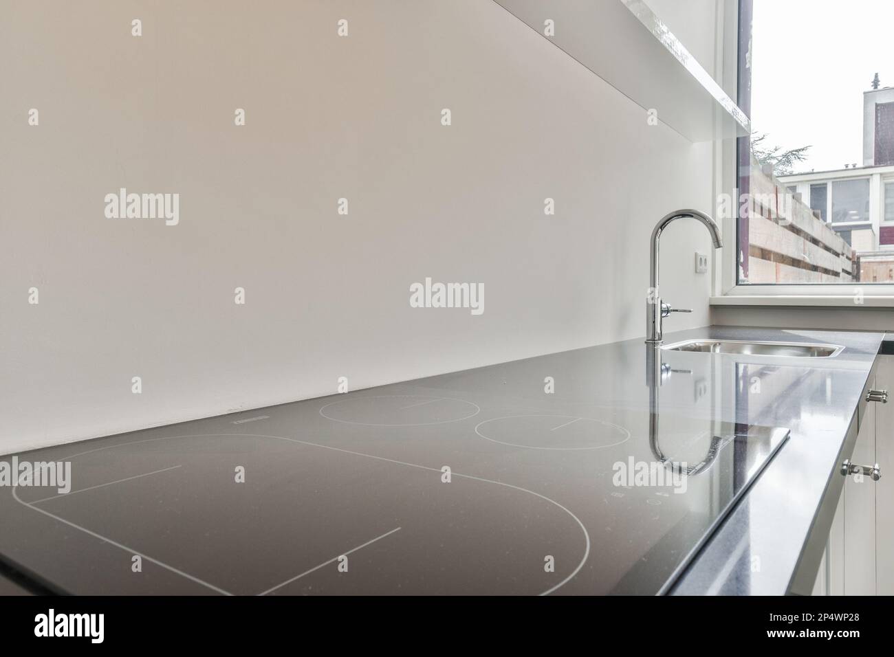 a modern kitchen with black counter tops and white cabinets in the ...
