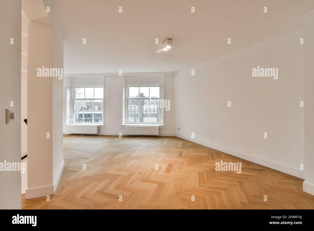 an empty room with wood flooring and white walls on the right side ...