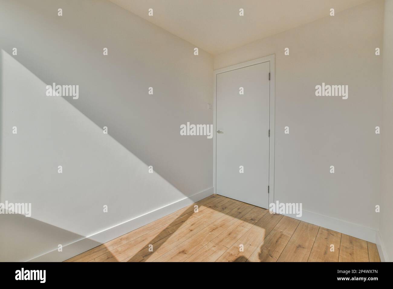 an empty room with white walls and wood flooring the door is open on ...