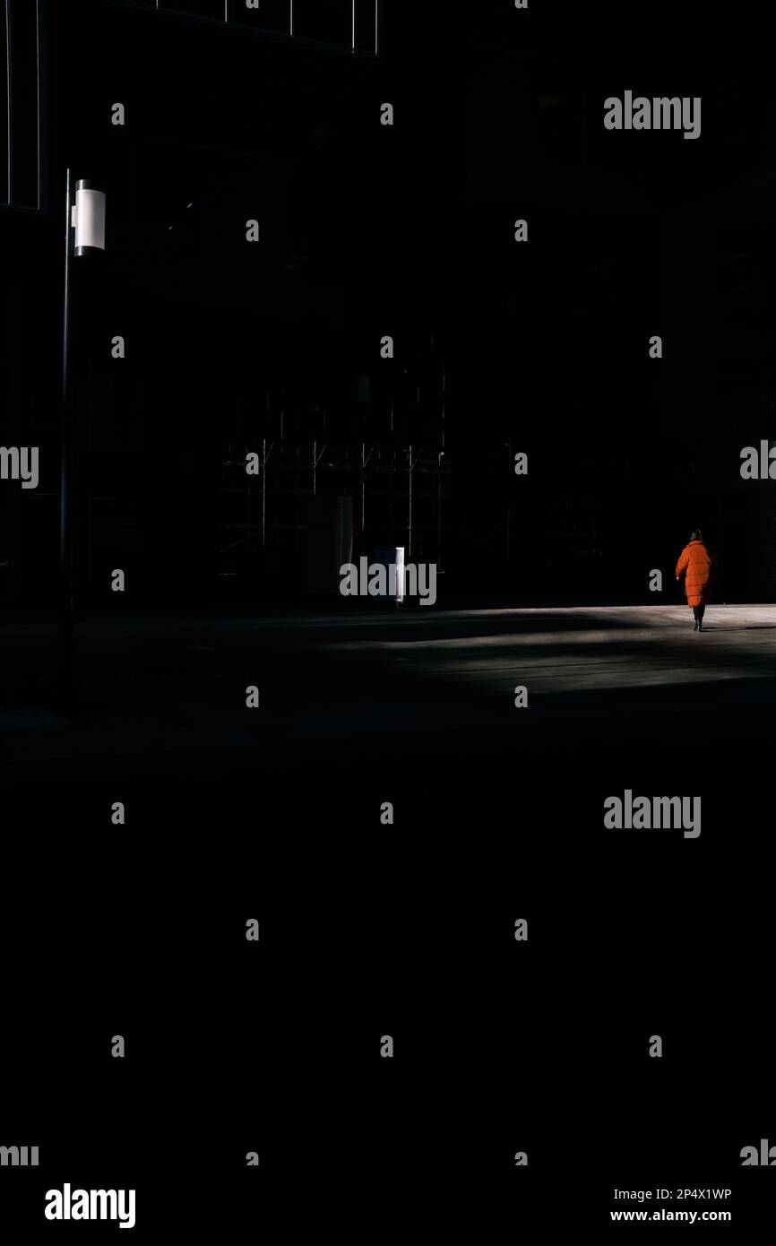 A female adult walking on a paved road at night Stock Photo - Alamy