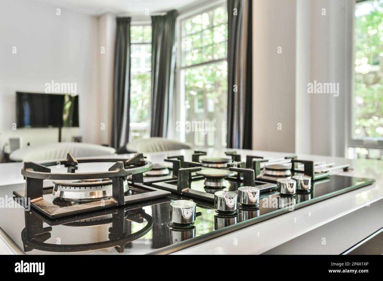 a stove in the middle of a room with large windows and lots of light ...