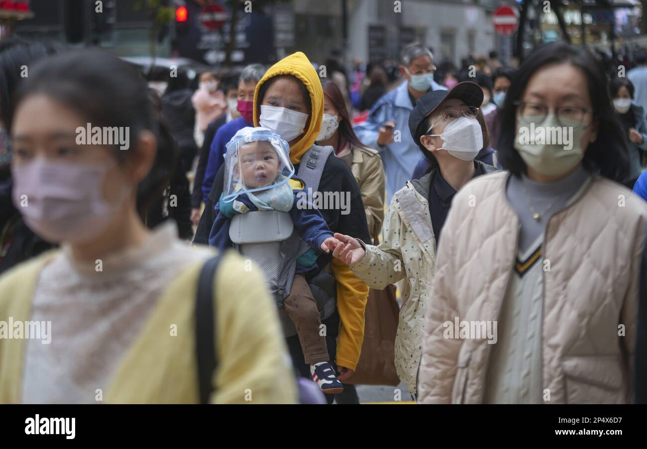 A woman carrying a baby at Causeway Bay.16FEB23 SCMP / Sam Tsang Stock ...