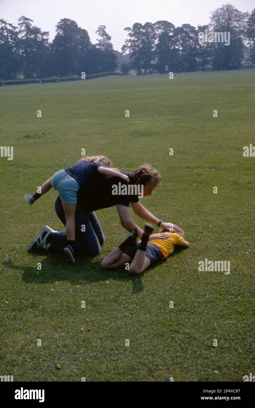 A dad playing with his 7 year old son and 5 year old daughter in the ...