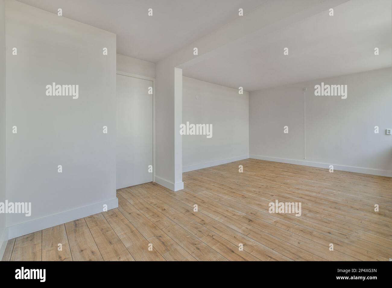 an empty room with white walls and wood flooring on the right side ...