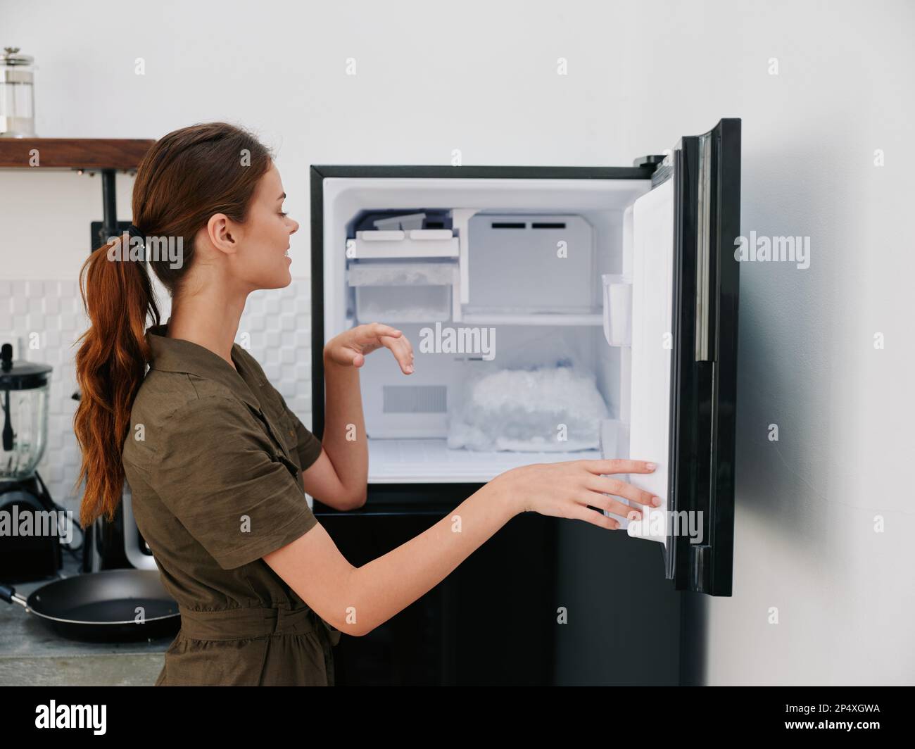 Woman smiling with teeth looking into camera in kitchen at home opened ...