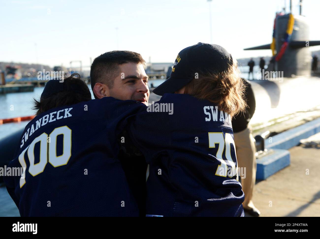 Lt. Commander Brad Swanbeck is hugged by his sons Parker and Braxton as ...