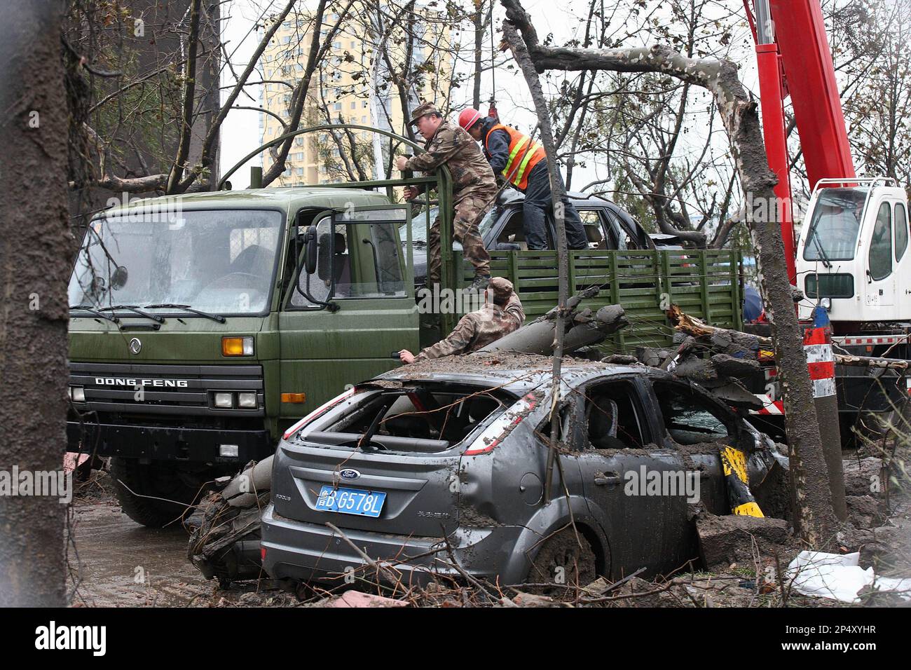 Rescuers clear damaged cars after a pipeline explosion in Qingdao in ...