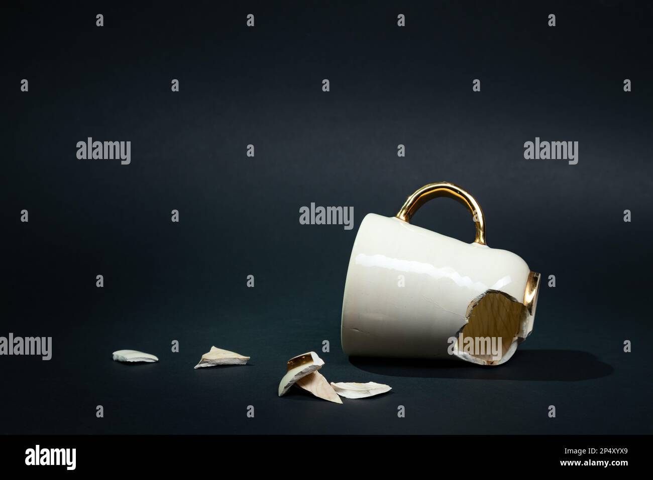 Broken tea cup isolated on black background. Cracked coffee mug and ...