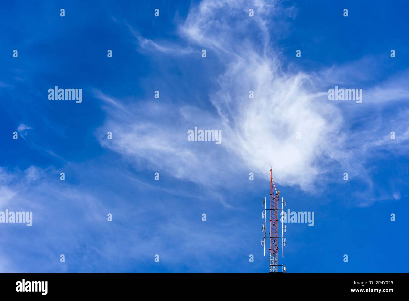 Telecommunication radio wave signal tower red and white with cloudy. Steel truss of transmission ...