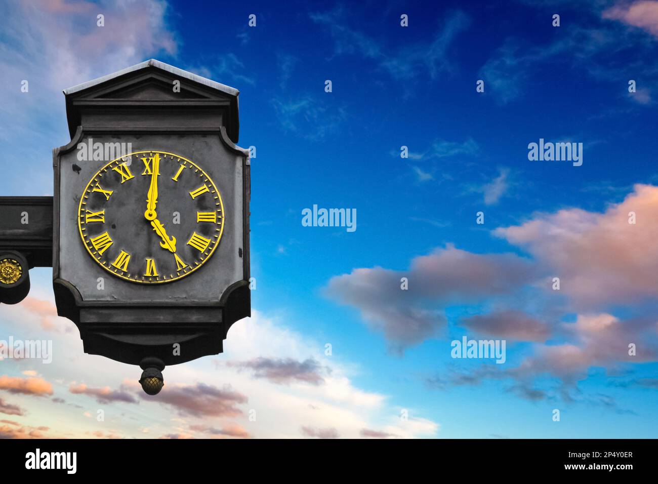 End of the work day. Old street clock showing 5 o'clock with colorful ...